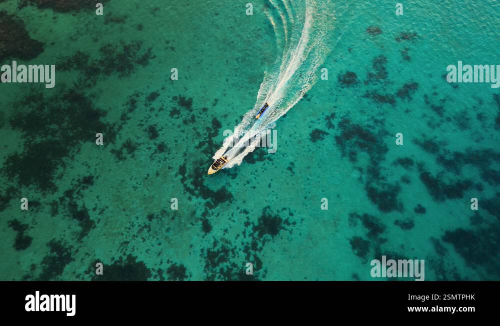 Aerial view of jet pulling a water banana boat in the sea with people ...