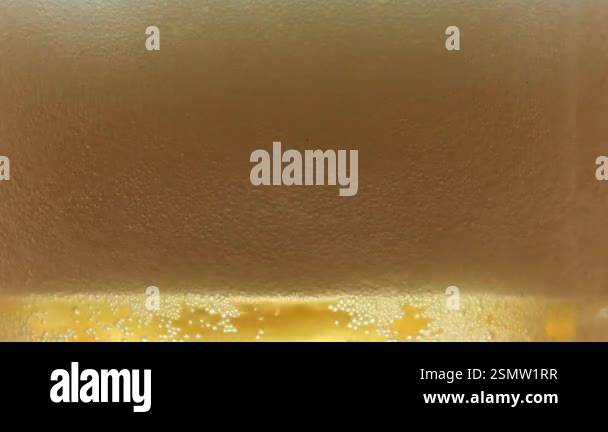 Extreme close-up of golden beer with fizzy bubbles rising to the ...