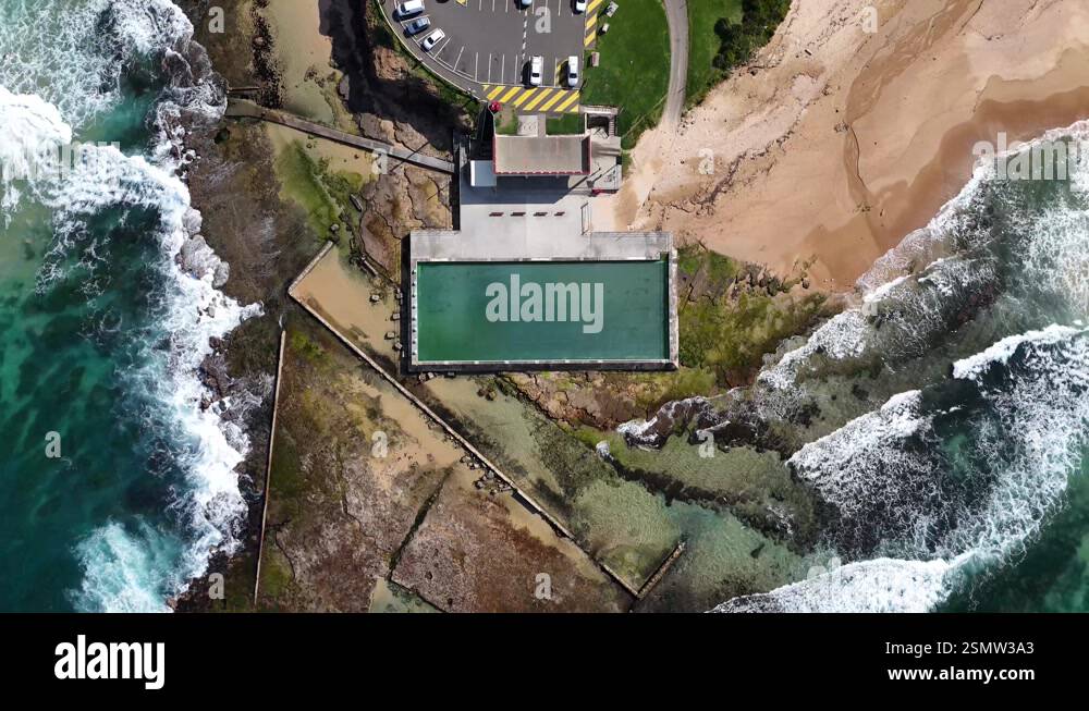 Aerial top down of rock pool at Woonona Beach with waves crashing over ...