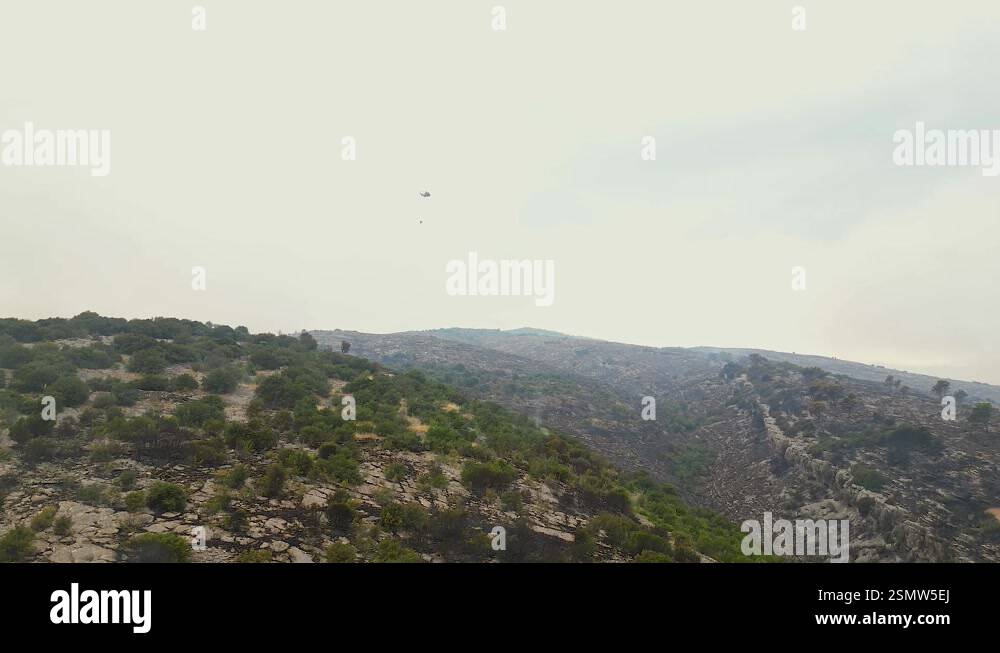 Firefighter helicopter unloading water on wildfires using bucket ...