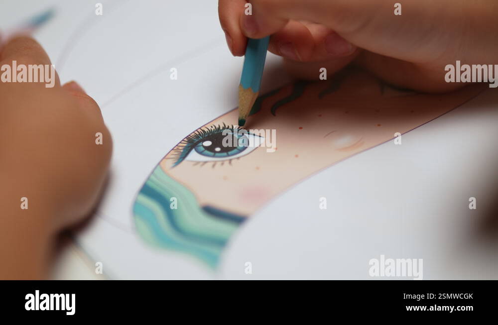 Close-up of a young girl coloring a pre-drawn picture with vibrant ...