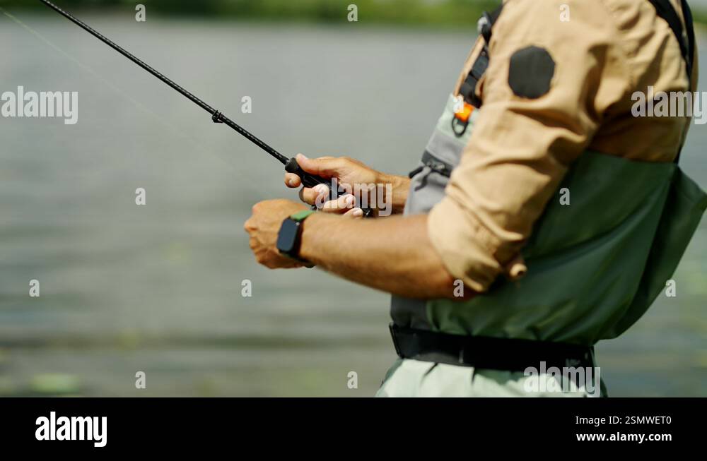 Fisherman With Rod Tackles. Fisher In Waders. Angler Catching Fish ...