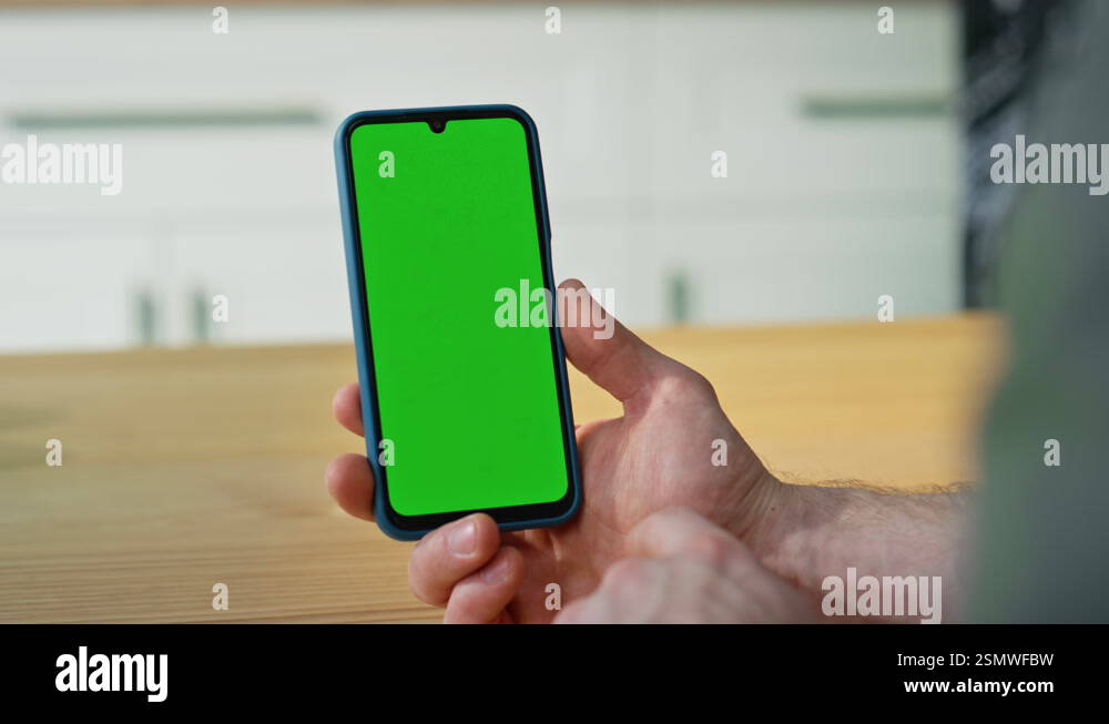 Man scrolling chroma key mobile phone making online purchases at home ...