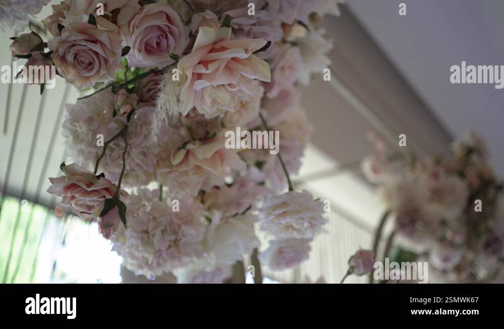 delicate pink and white roses in a hanging floral arrangement, creating ...