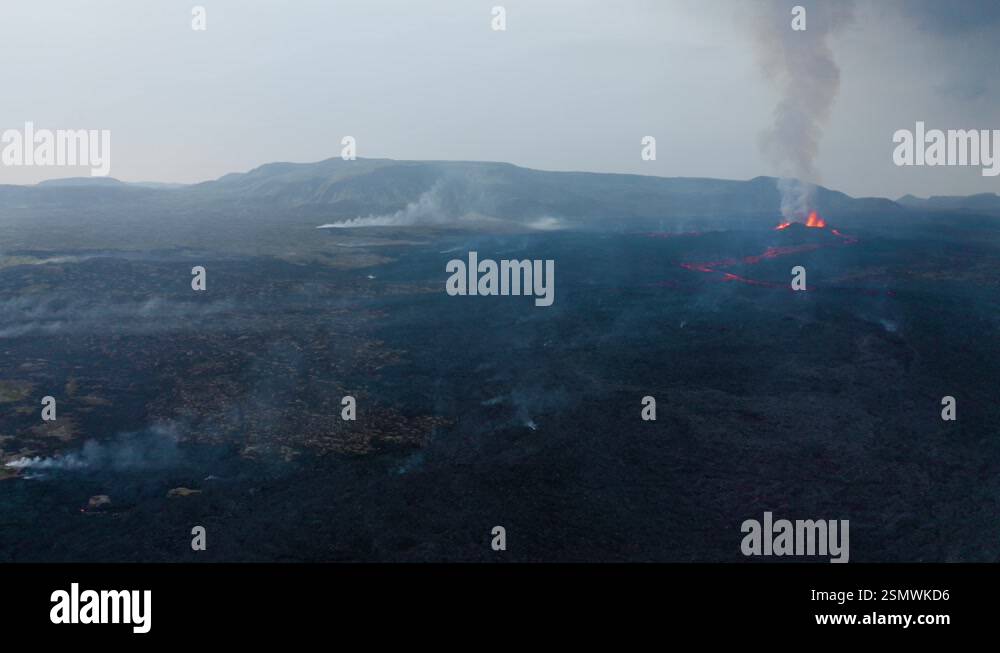 Aerial footage of Grindavik volcano erupting with visible steam rising ...