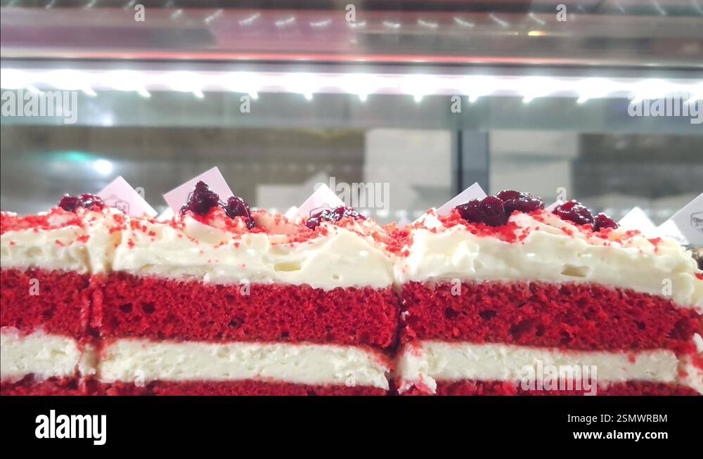 Red velvet cake slices with cream cheese frosting and berry toppings on ...