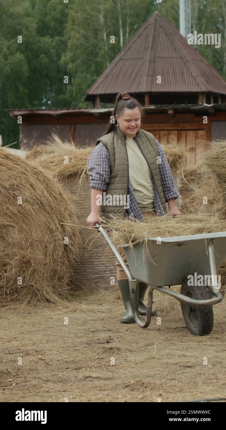 Woman with Down Syndrome Helping Female Farm Worker Carting Straw Stock ...