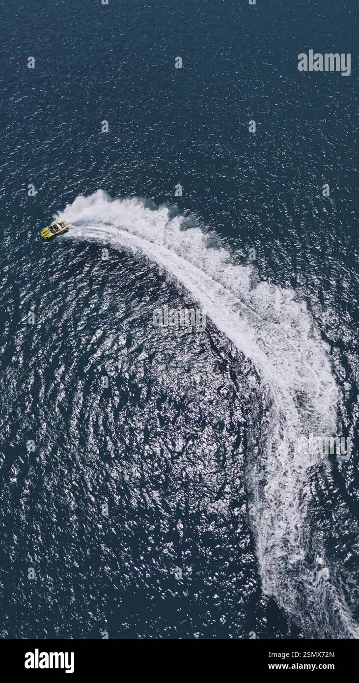 Aerial drone top view tracking video of yellow speed boat cruising and ...