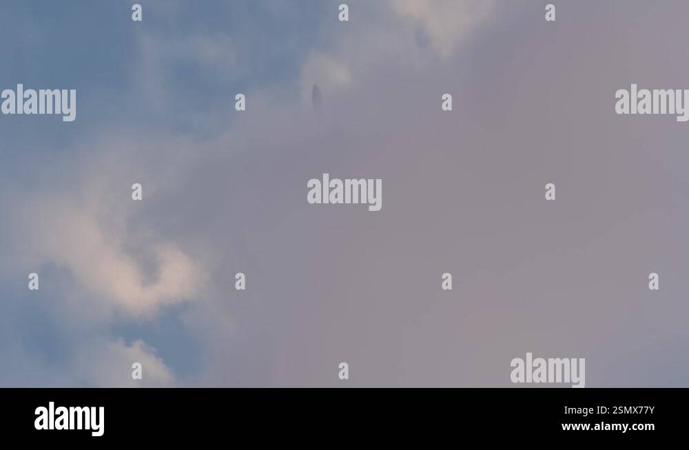 4k, a view from below of a passenger plane flying through the clouds in ...