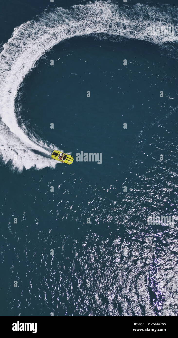 Aerial drone top view tracking video of yellow speed boat cruising and ...