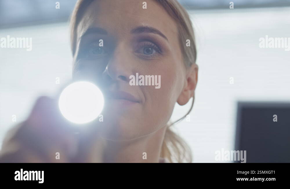 Closeup doctor using flashlight in clinic. Patient pov of medical ...