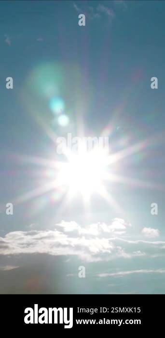 The sun, blue sky, bright sunny rays and clouds - Vertical video. High ...