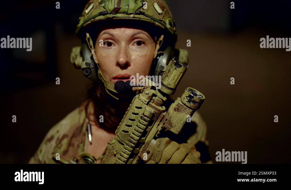 A female soldier equipped with a tactical helmet and microphone, with ...