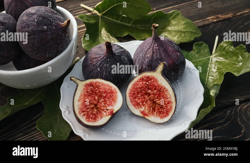 Delicate fresh ripe figs with leaves on white plate. Ficus carica. Top ...