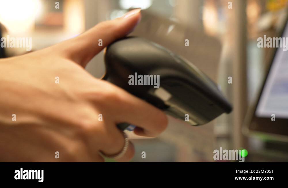 A salesperson scans the merchandise at the checkout counter. Close-up ...