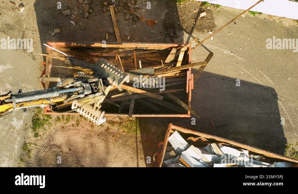 Overhead view showing an excavator loading wooden debris into a ...