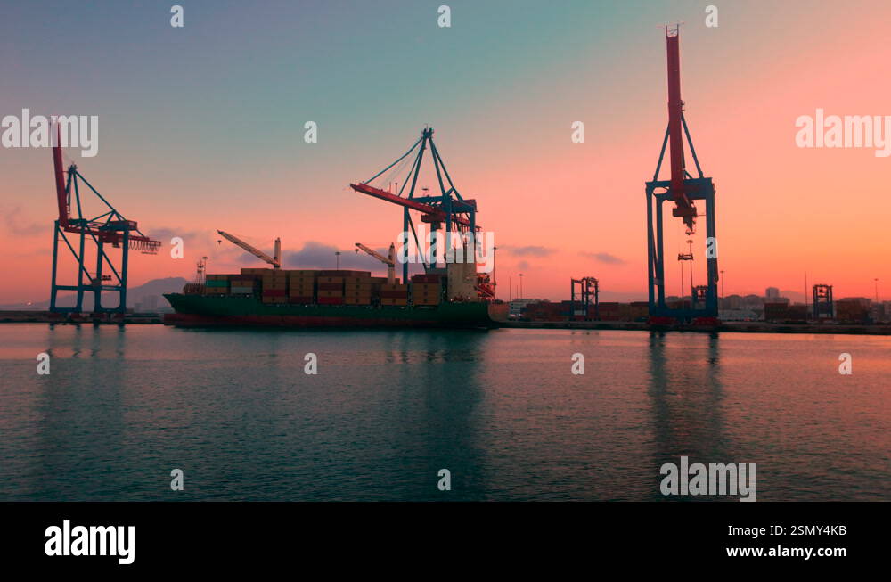 A cargo ship docked at the port of Málaga, Spain, with large container ...