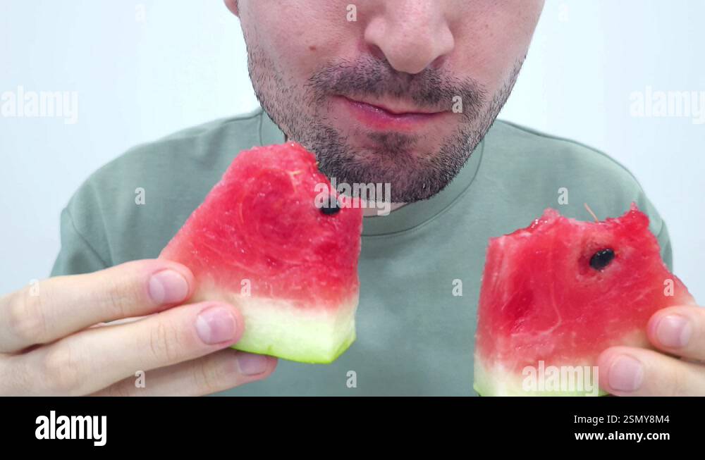 Man greedily eating watermelon slices. Healthy eating and summer fruit ...