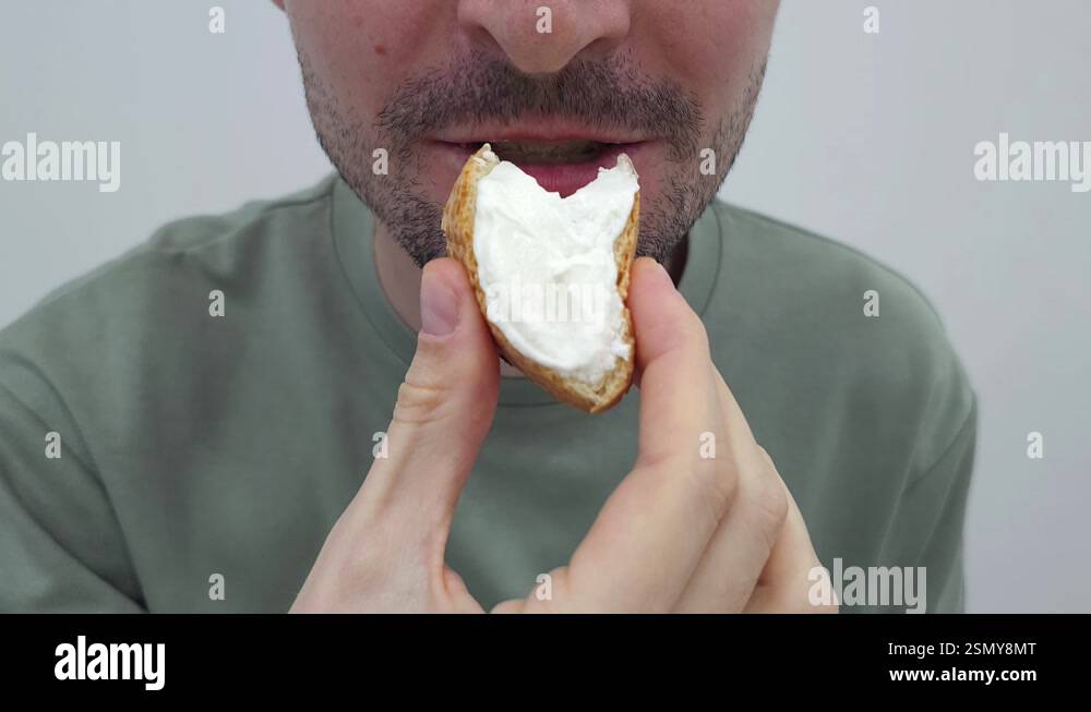 Man eating bread with cream cheese. Close-up of hands and food Stock ...