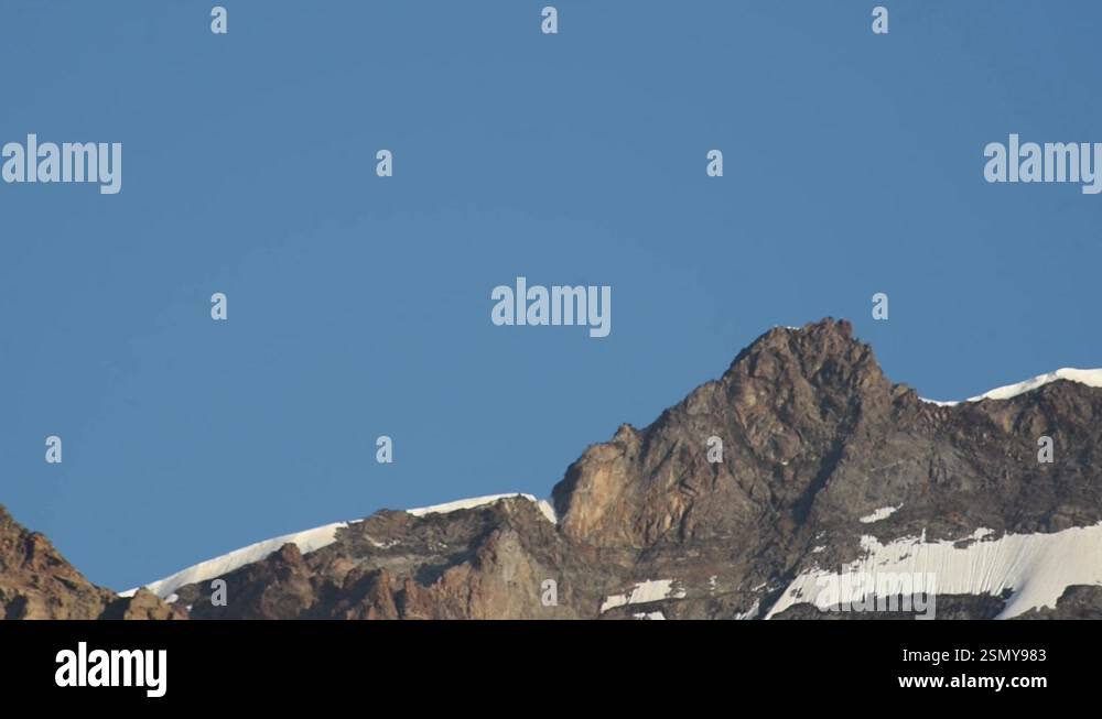 Close up slide over the sunset lit summit of Monte Rosa. Europes second ...