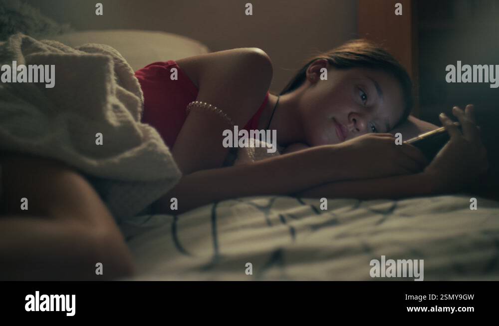 A teenage girl lies lazily on her bed, scrolling through social media on Stock Video Footage - Alamy