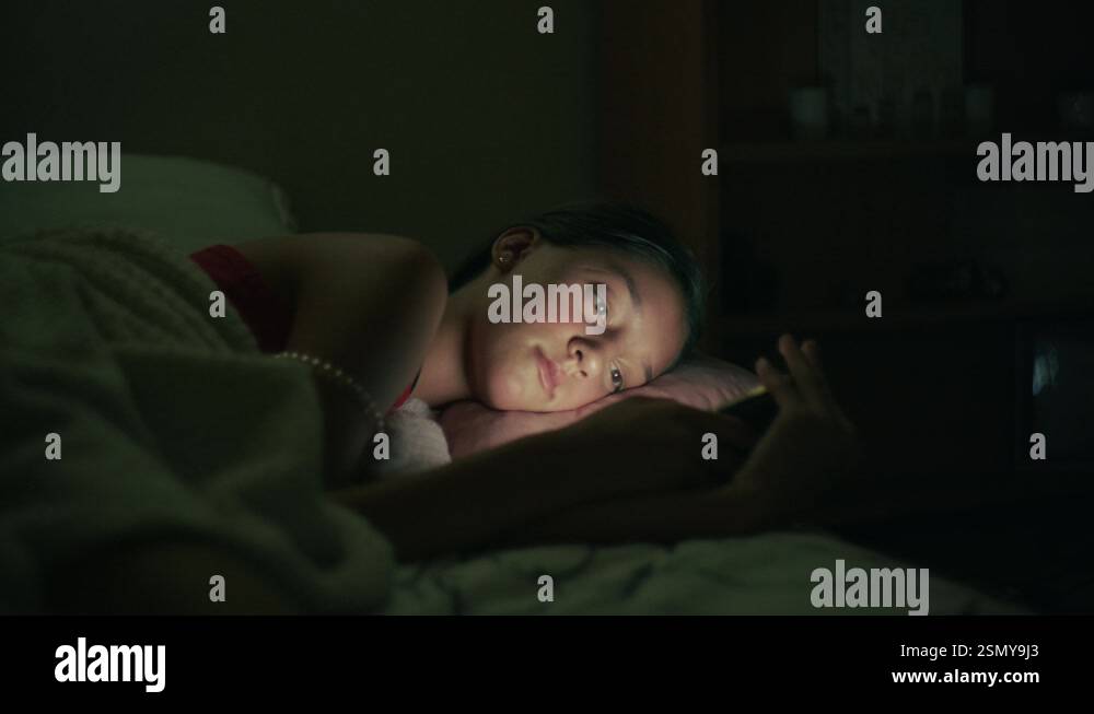 A teenage girl lies lazily on her bed, scrolling through social media on Stock Video Footage - Alamy