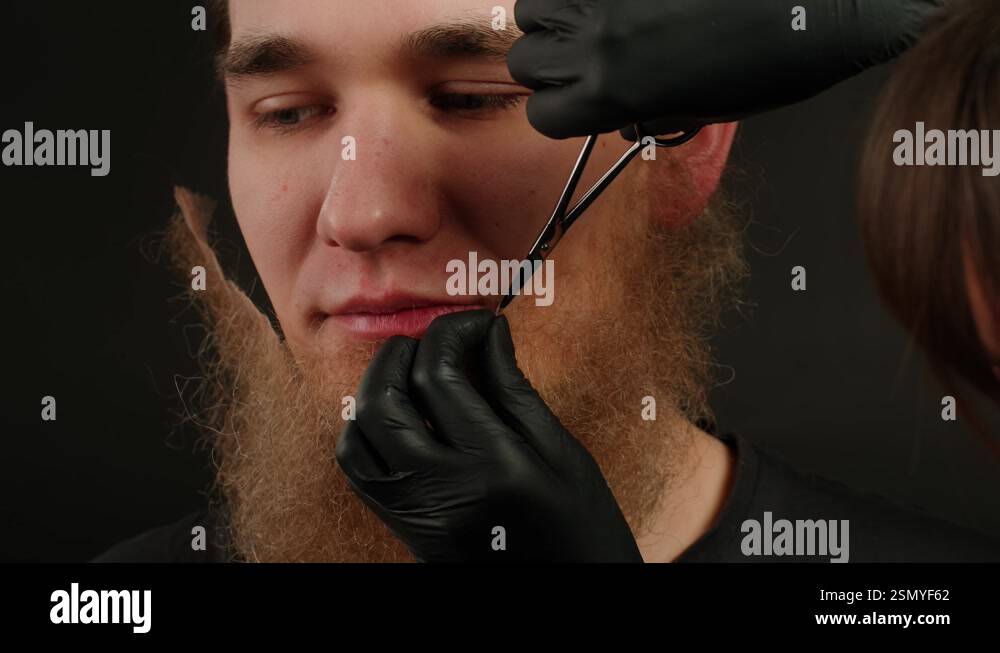 Make up artist making Disheveled blond beard for a man in theater with ...
