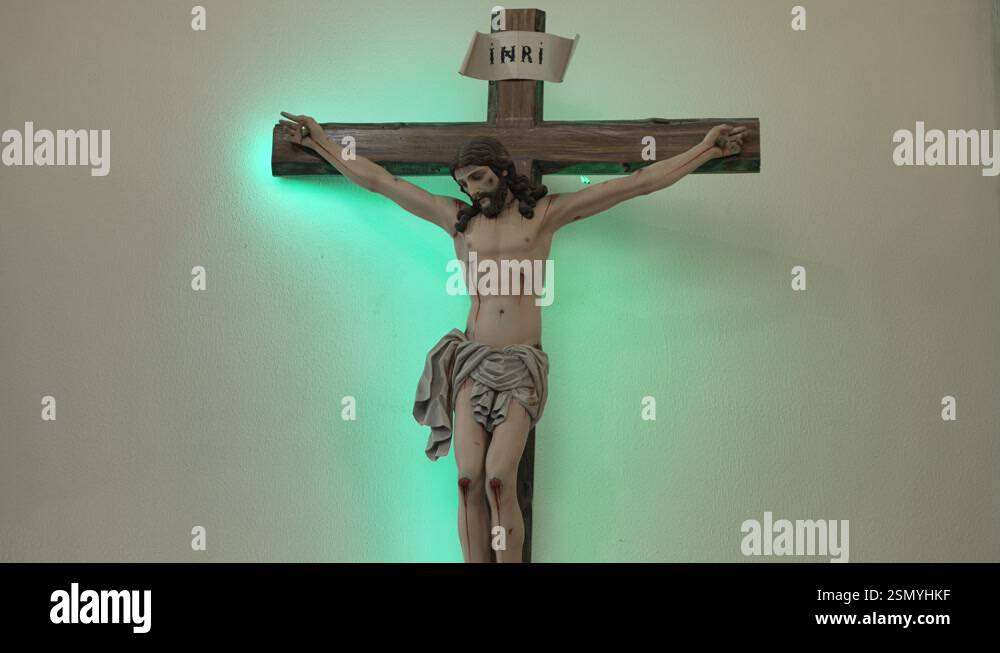 crucifix of Jesus Christ illuminated with a soft green light in a church Stock Video Footage - Alamy