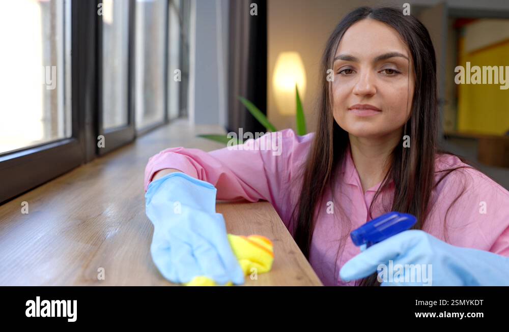 Woman is wiping dust using a spray and a duster while cleaning her house Stock Video Footage - Alamy