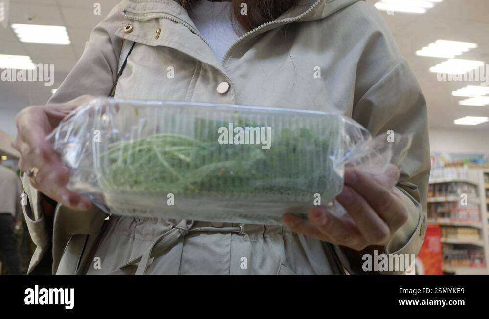 Close-up buyer woman buying greens arugula in packaging. Food ...