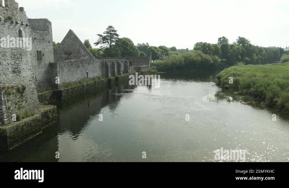 Ruins of Adare Castle overlooking calm river Maigue on a sunny day in ...