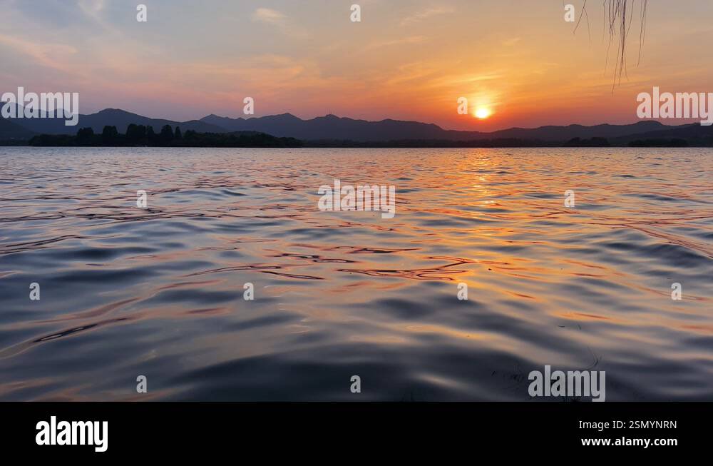 A tranquil sunset over West Lake (Xi Hu) in Hangzhou, China. The sun ...