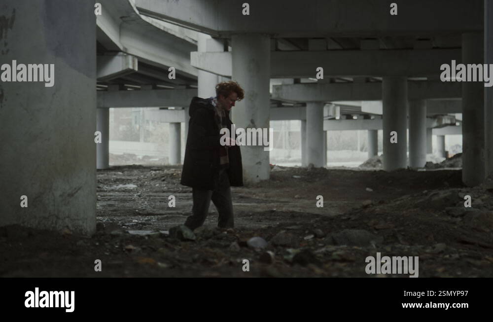 Unhappy Young Man Staggering while Walking under Bridge and Smoking ...