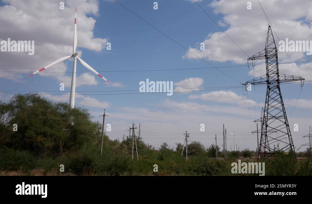 Rotating Windmills and Power Line. Turning wind turbines, moving clouds ...