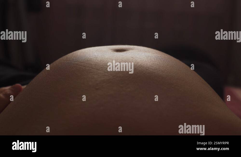 Close-up footage showing an unborn baby moving visibly inside a 6-month ...