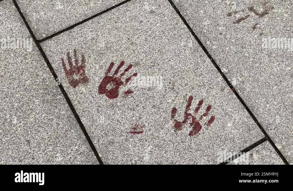 Red handprints on gray pavement evoke mystery and intrigue in a close ...