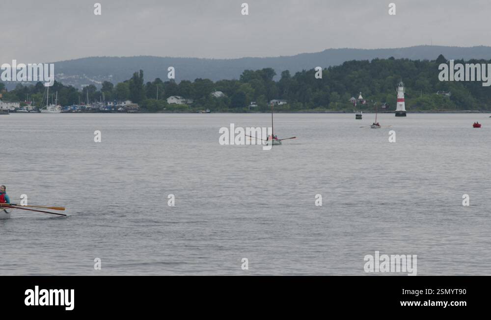 Oslo, Norway - 09/04/2024: Kids in a rowing class on a calm river with ...