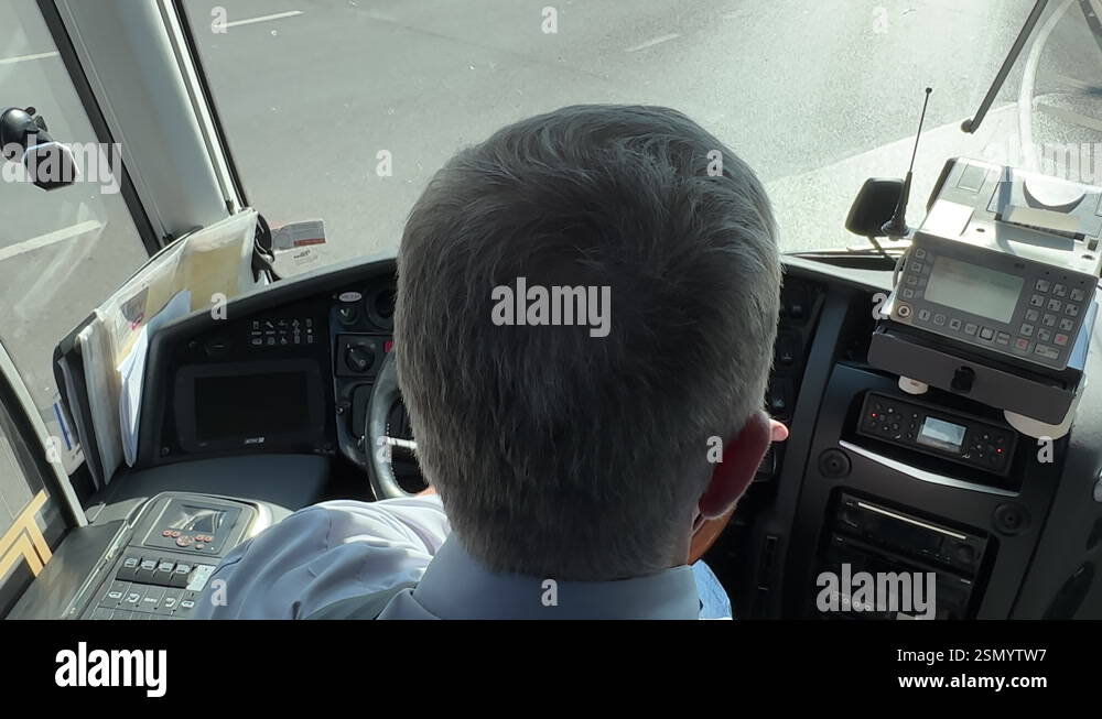 Coach driver rear view driving in the city, focus on bus dashboard ...