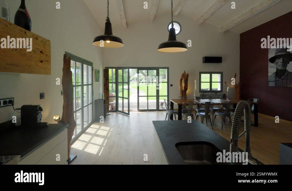 Slow pull-out shot revealing an open plan dining room and kitchen in a ...