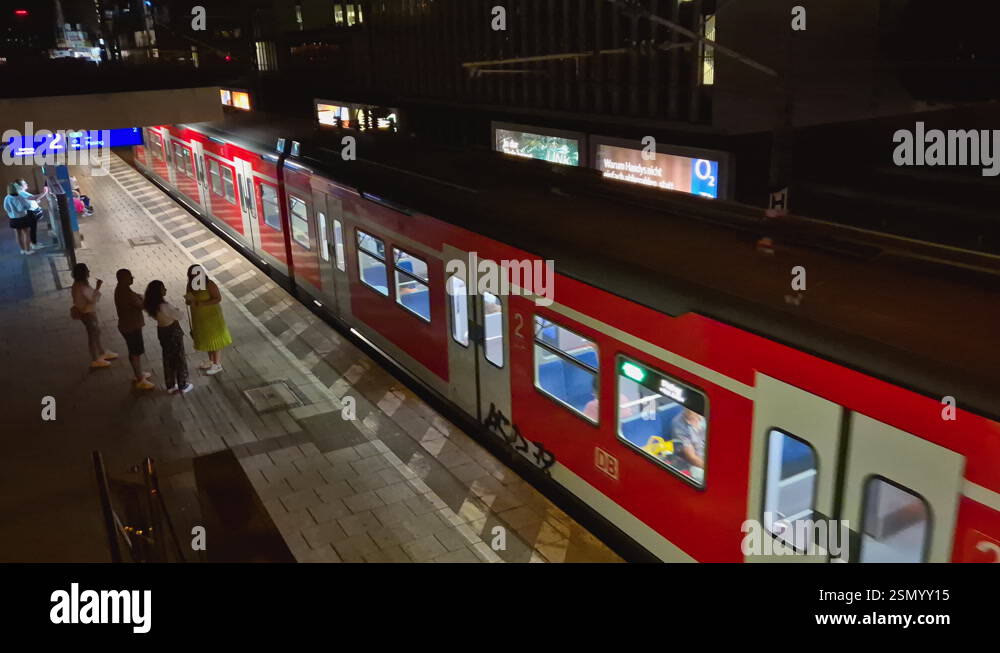 Munich, Germany - 08/23/2024: Train stops at a rail station at night in ...