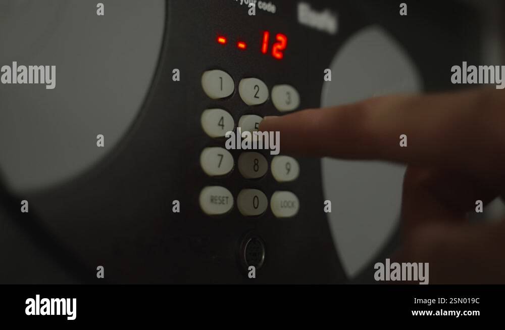 Close up on hand punching keypad and opening security safe box or vault ...