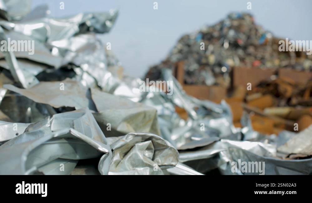 Scrap metal piles at a junkyard with a distant focus, panning shot ...