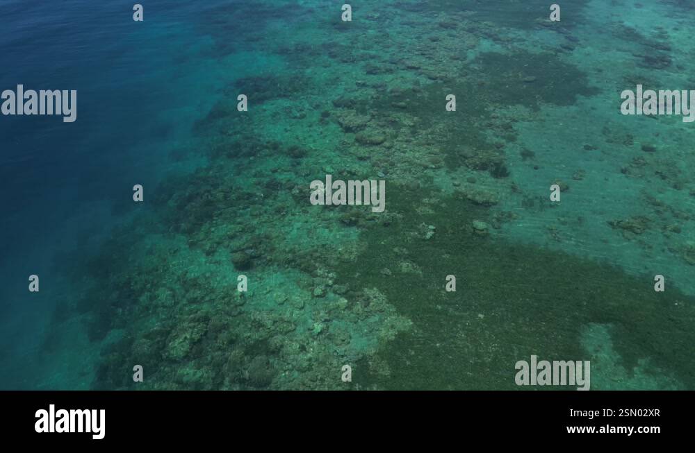 Clear ocean water with coral reefs below, viewed from above on a calm ...