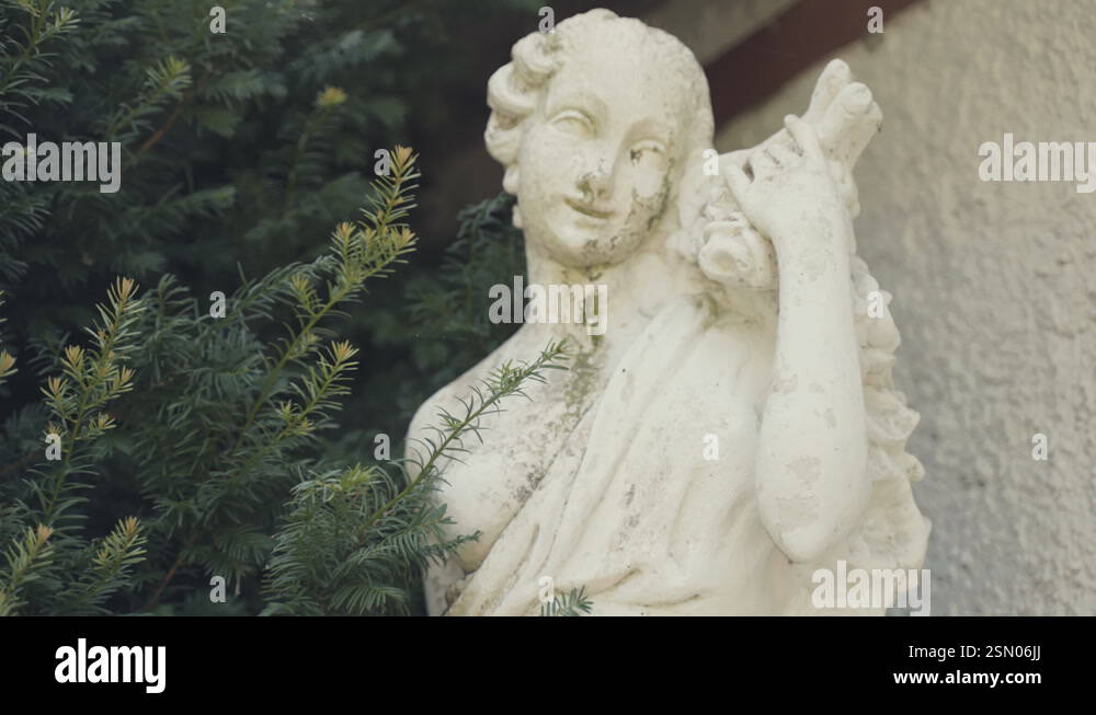 Antique sandstone statue of mythical character overgrown with green ...