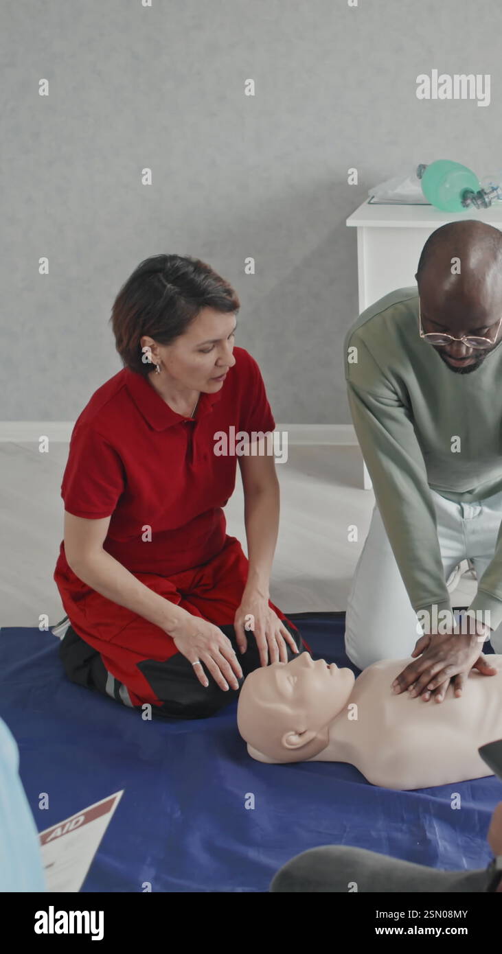 Female First Aid Responder Teaching Man to Perform CPR on Dummy Stock ...