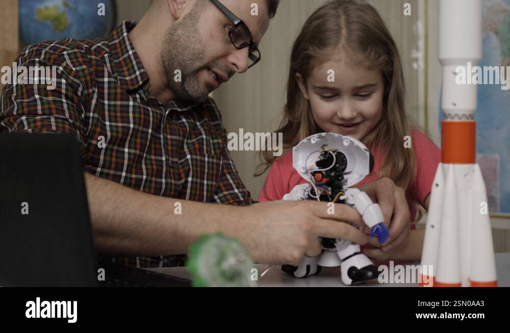 Dad and Daughter Assemble Robot at Home. Education Science, Technology ...
