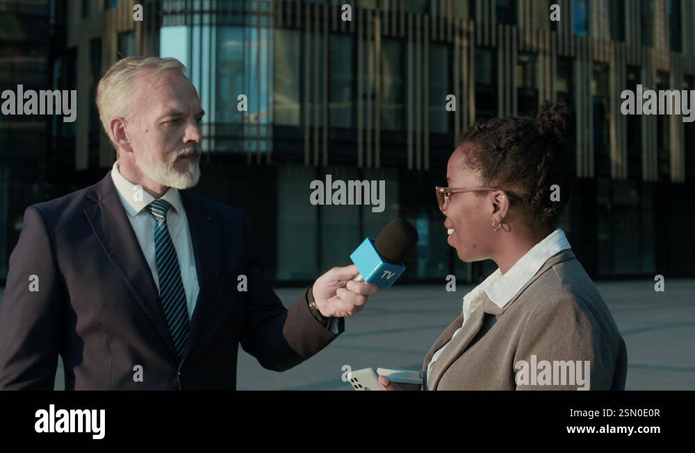 TV Reporter Conducting Interview with Businesswoman in Cityscape Stock ...