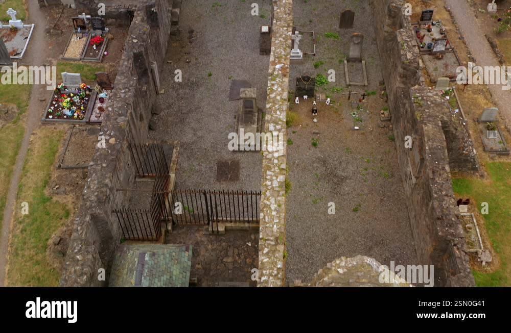 Drone tilt down above St. Mary's Abbey Ruins in Howth with gated ruins ...