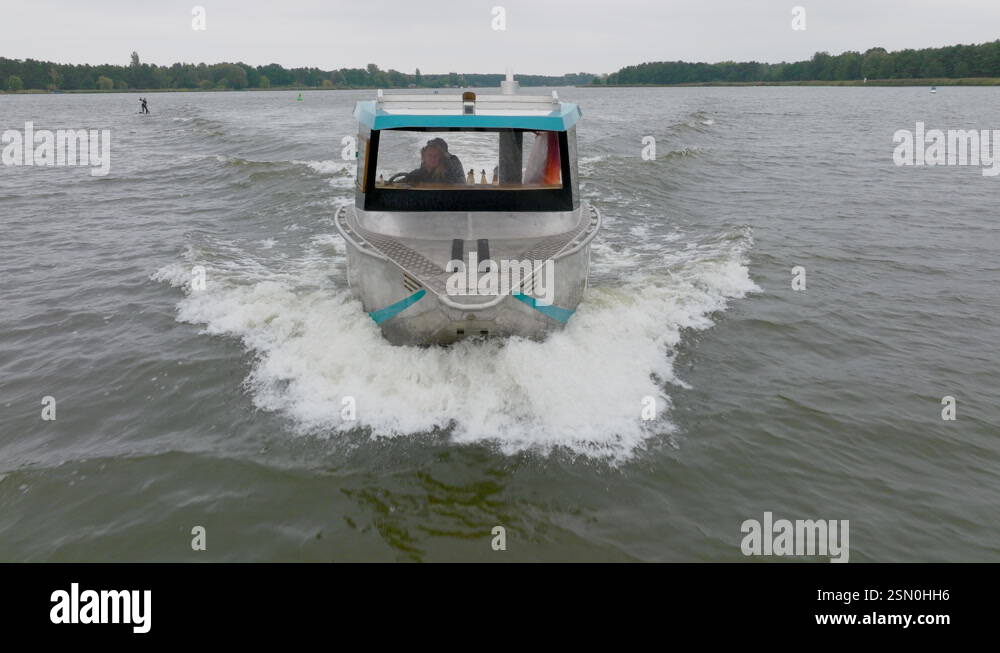 blond girl driving silver aluminum boat over river with trees on ...