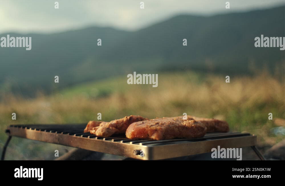 Preparation of bbq beef meat in grill grid outdoors above flame at ...